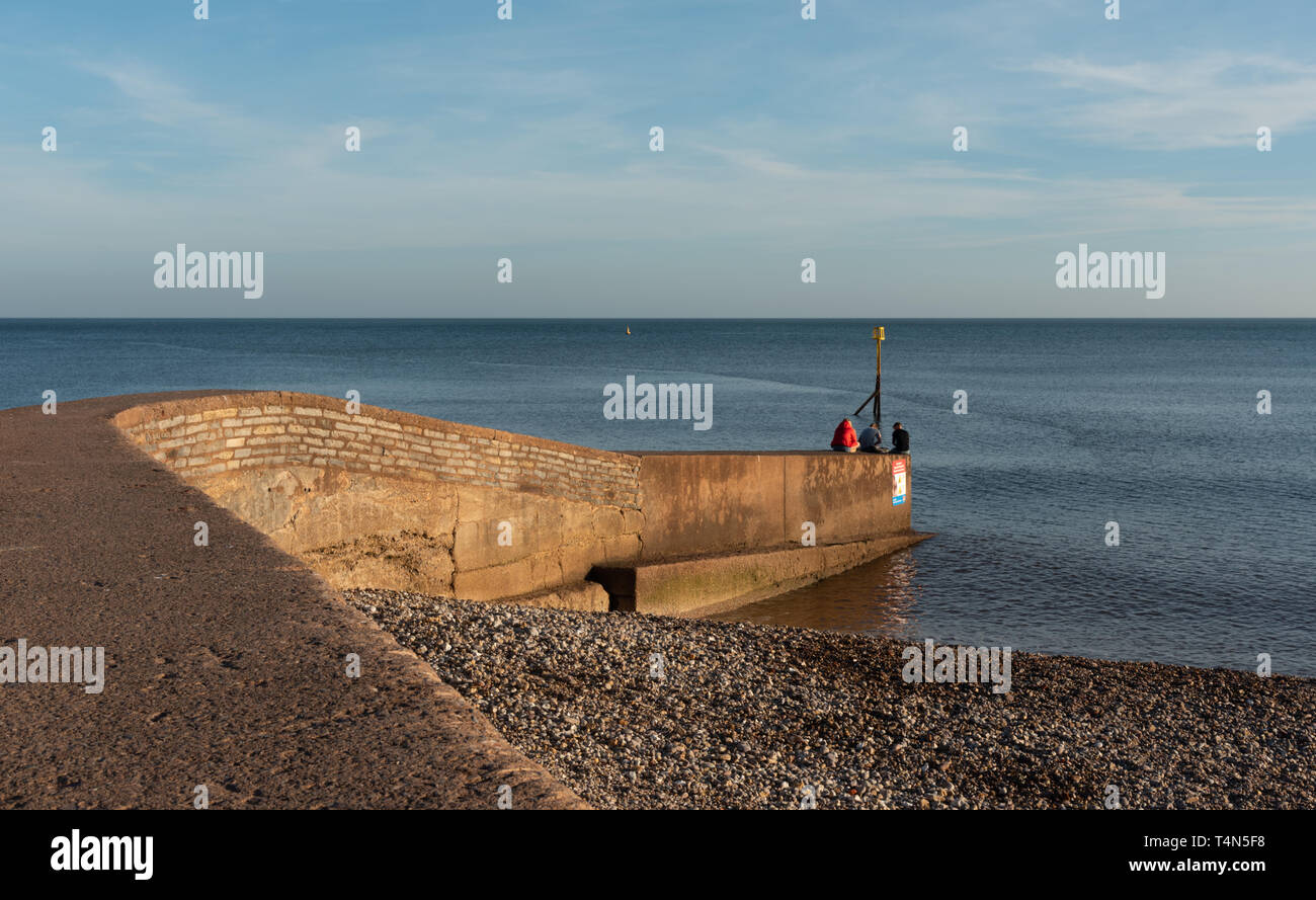 Three friends on groyne at Sidmouth, Devon Stock Photo - Alamy