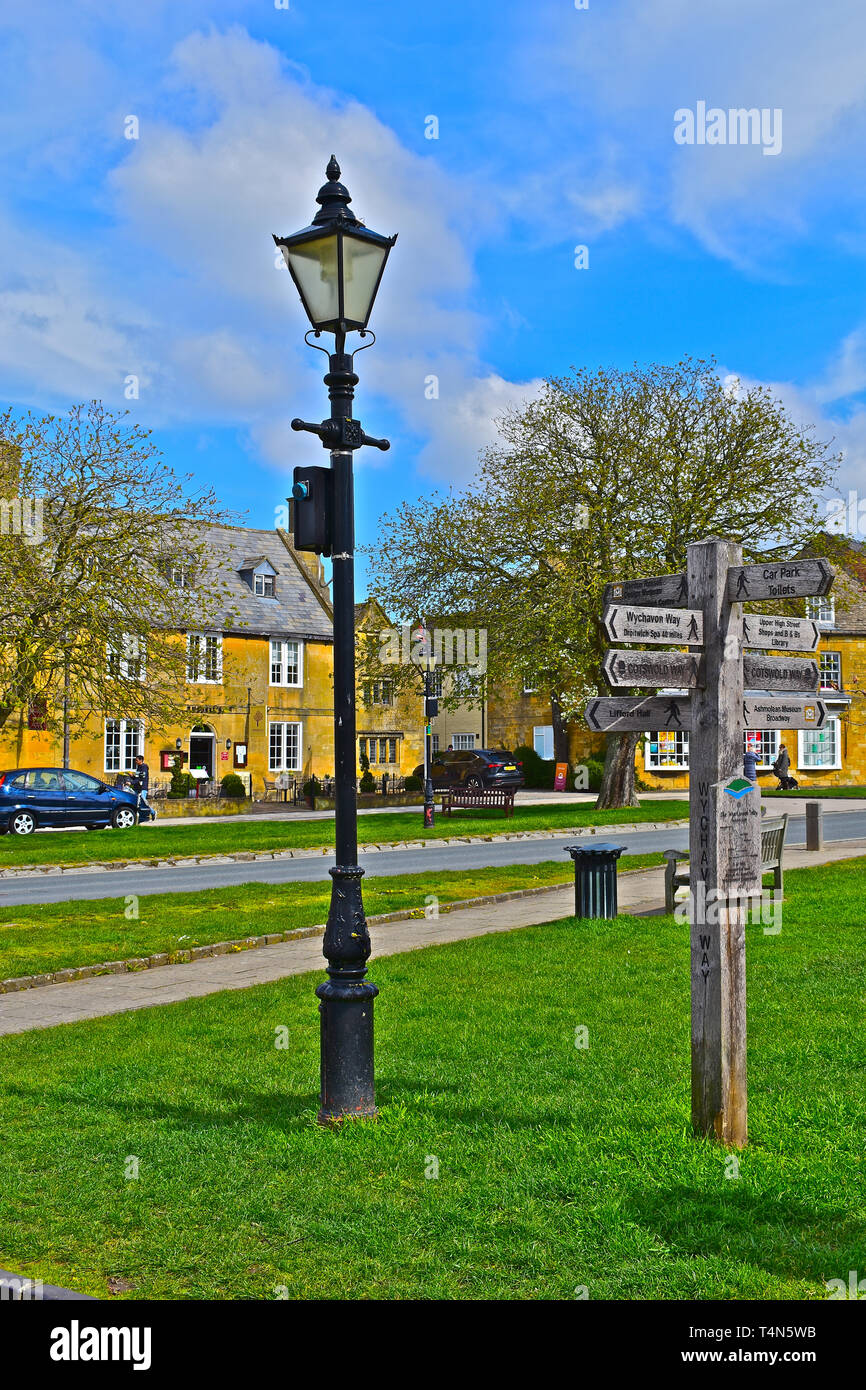 Old fashioned style lamp post and weathered wooden signpost in the ...