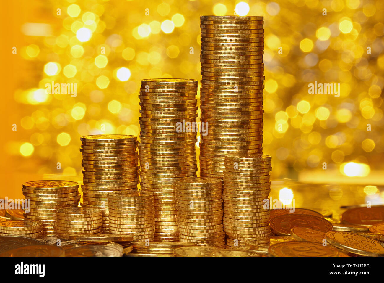 Coins stack on golden bokeh background Stock Photo - Alamy