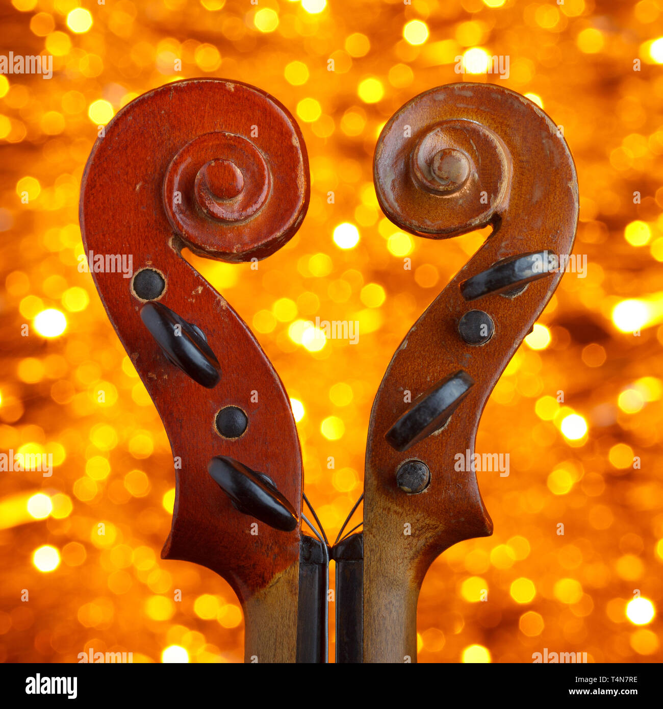 Two vintage violin scrolls on bokeh background Stock Photo - Alamy