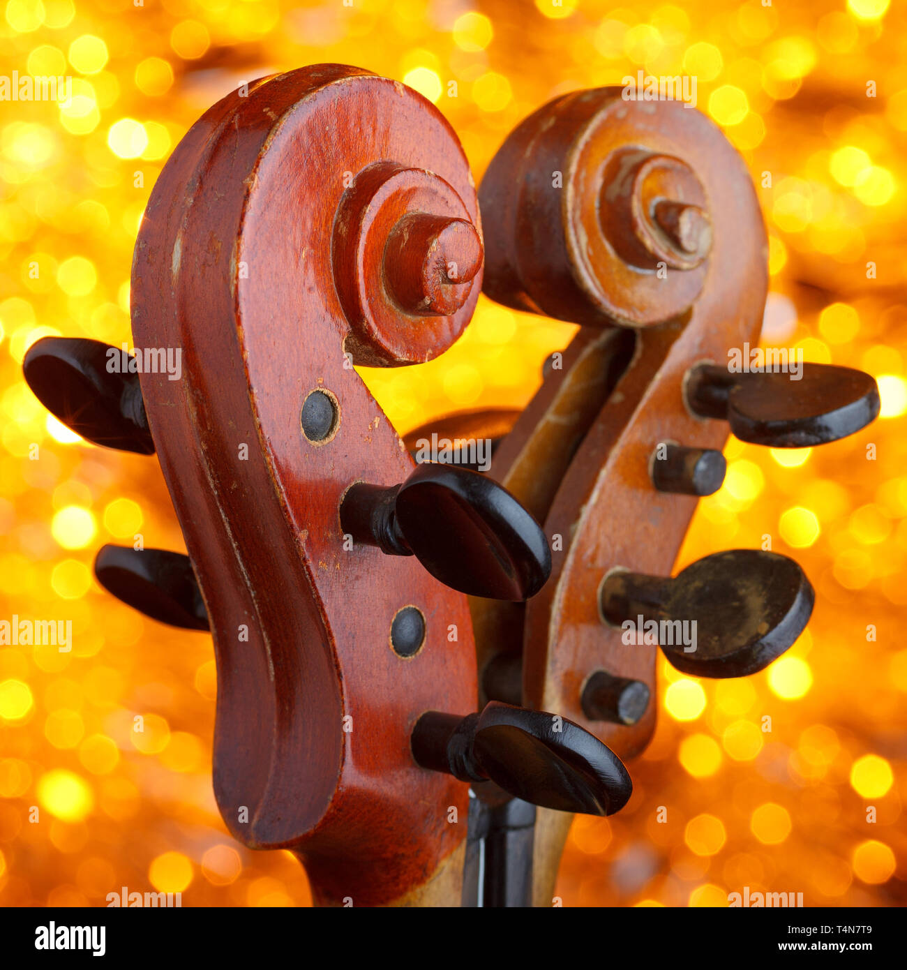 Two vintage violin scrolls on bokeh background Stock Photo - Alamy