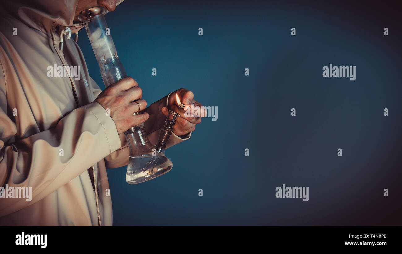 The person smoking marijuana with bong, close-up. Bong in the hand ...
