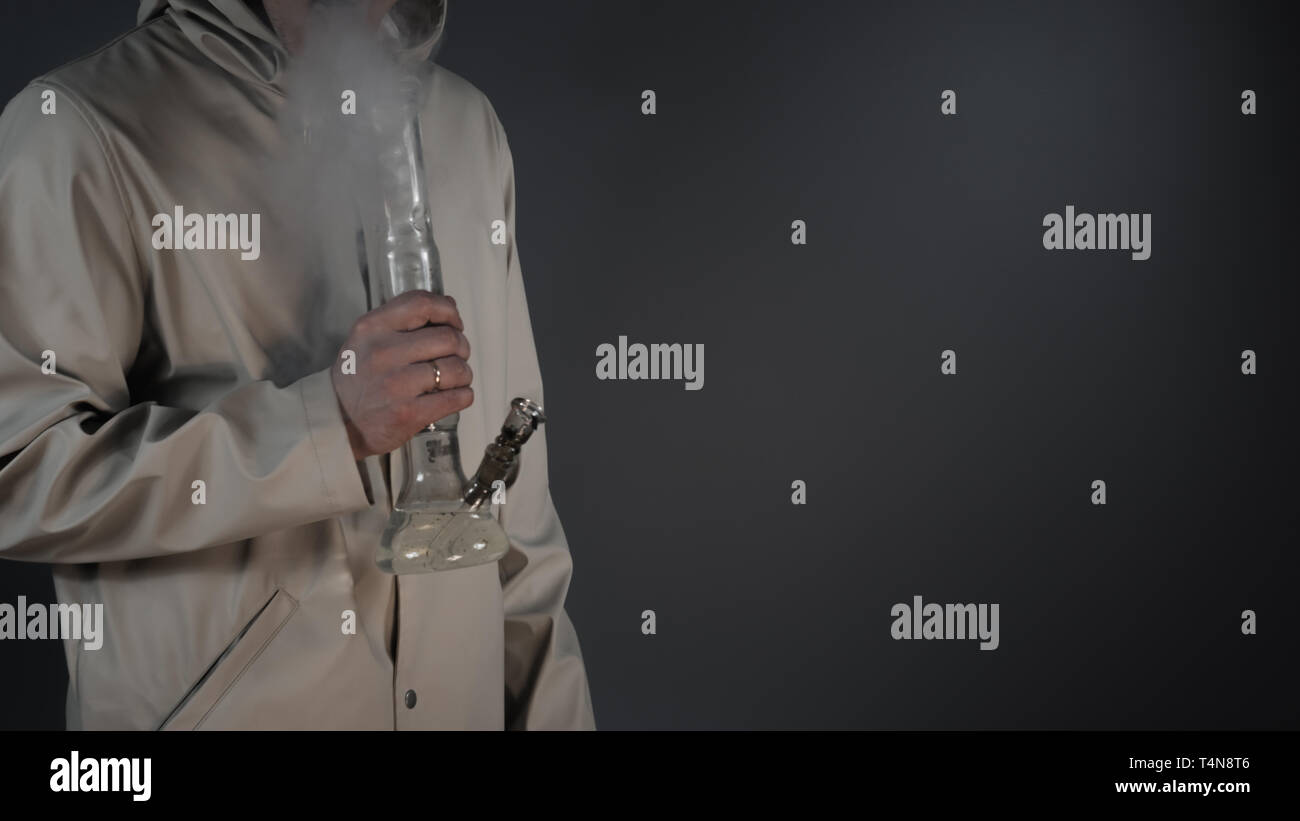 The person smoking marijuana with bong, close-up. Bong in the hand ...