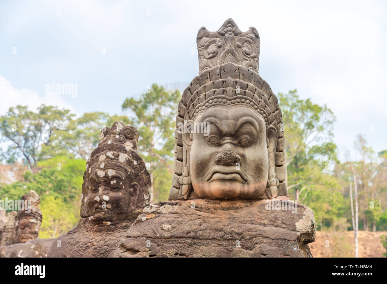 Ancient Hindu statues along sides of the south bridge into Angkor Thom ...