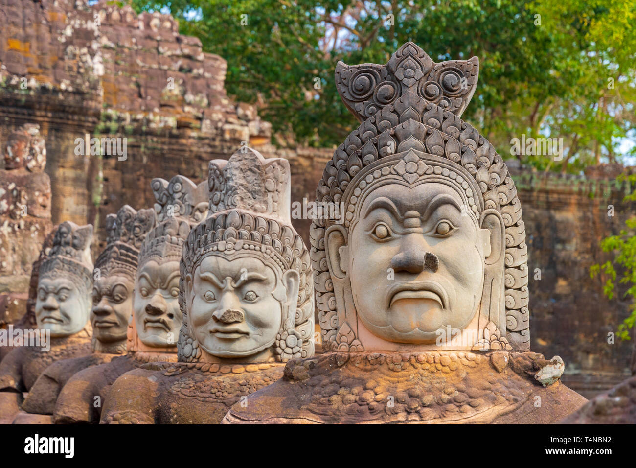 Ancient Hindu statues along sides of the south bridge into Angkor Thom ...