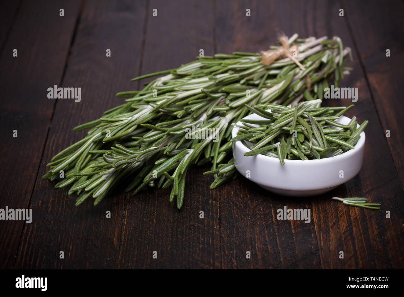Rosemary bunch and bowl on rustic wooden table still life Stock Photo ...