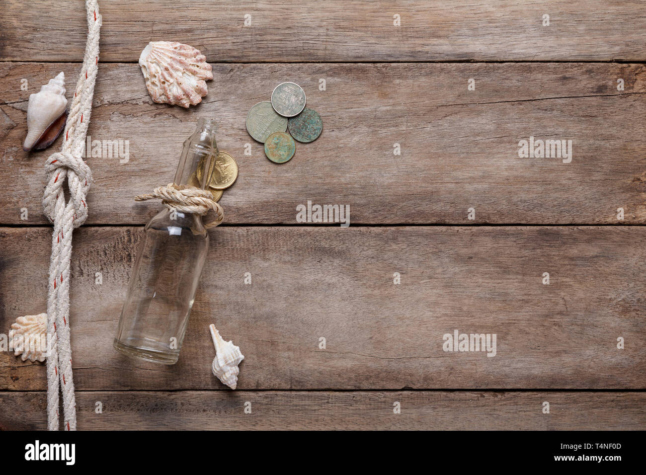 Weathered wooden table with rope, shells, message bottle and vintage ...