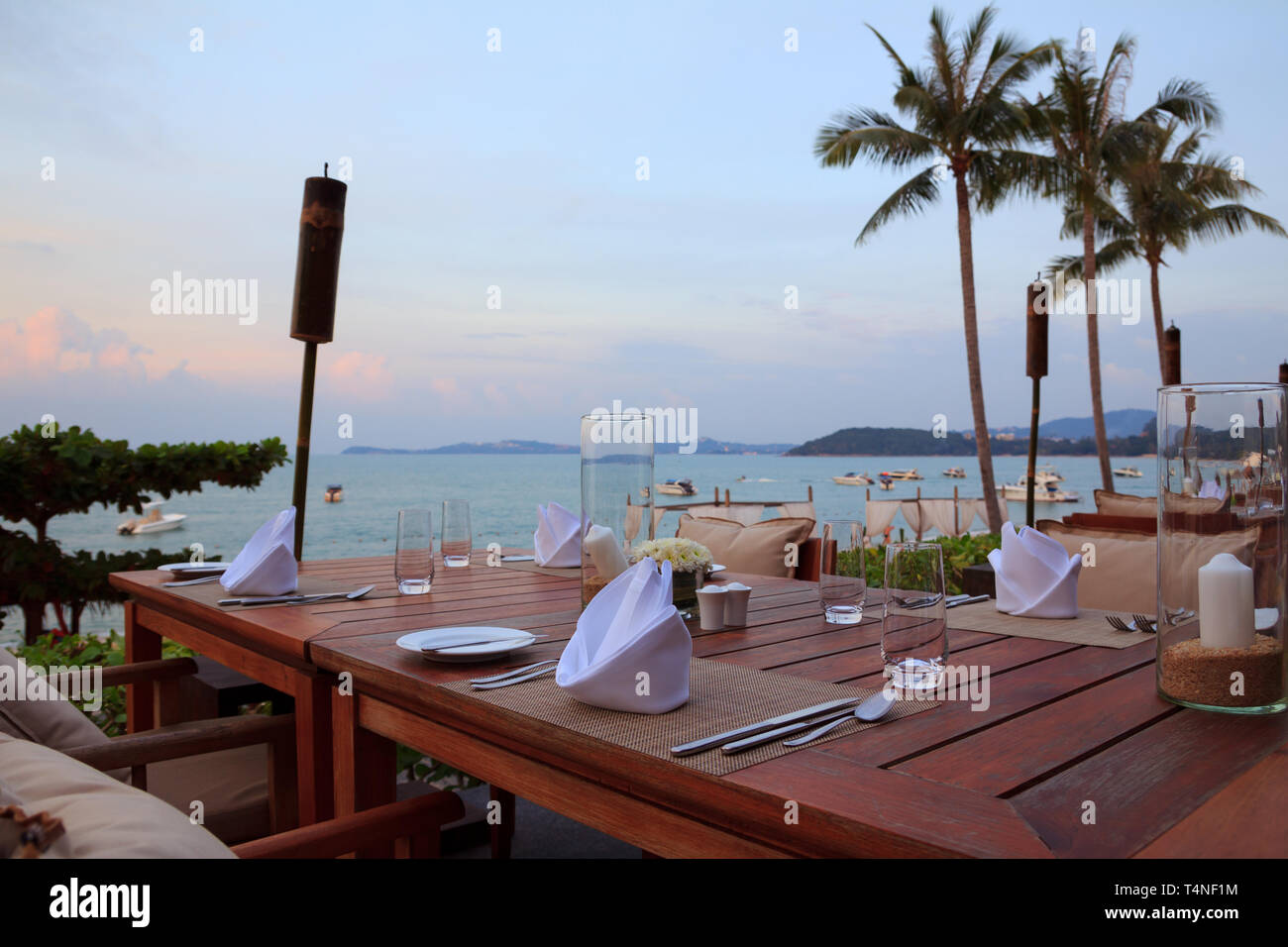 Outdoor restaurant tables, dinner setting at the beach on sunset Stock ...