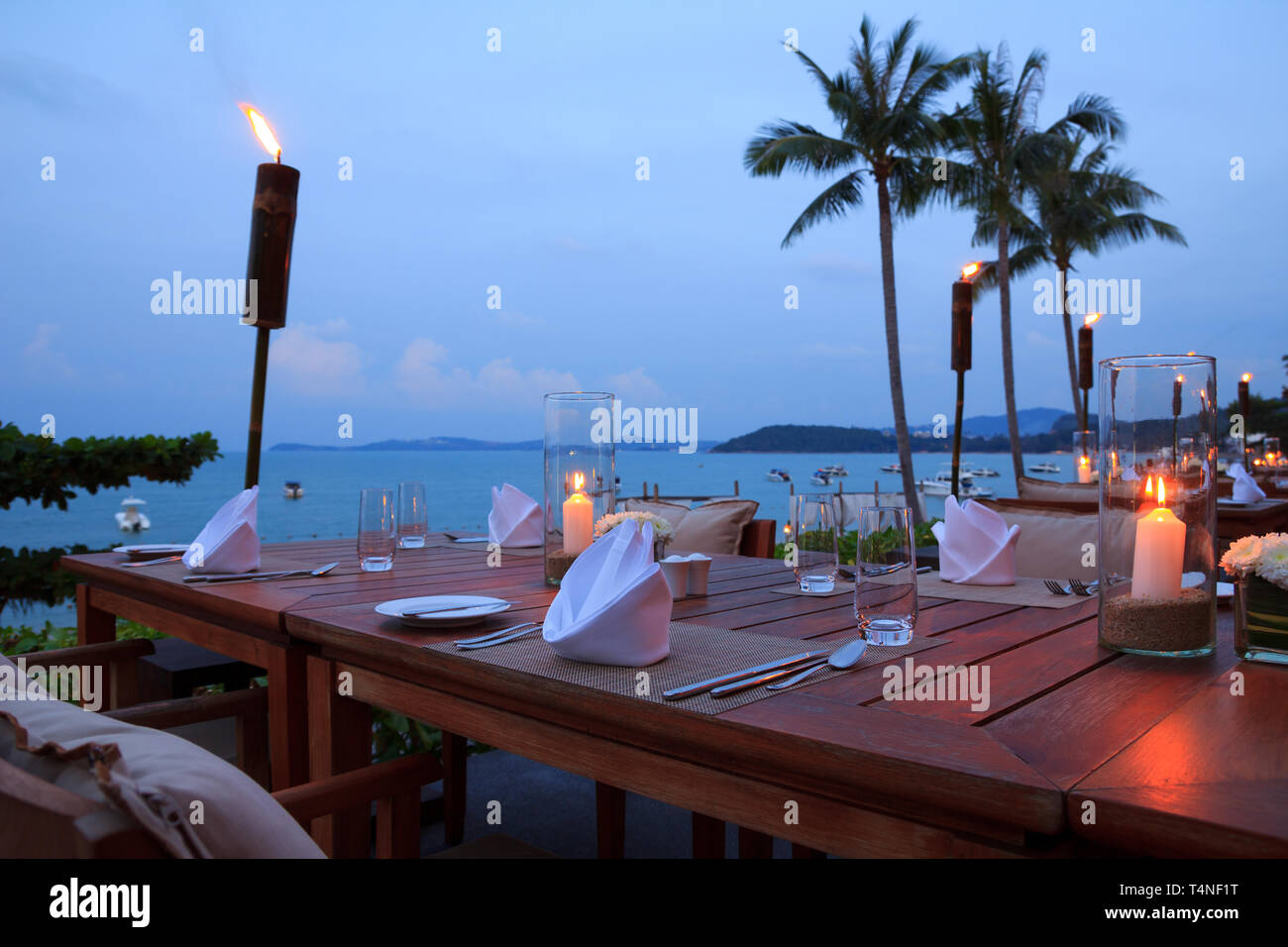 Outdoor restaurant tables, dinner setting at the beach on sunset Stock ...