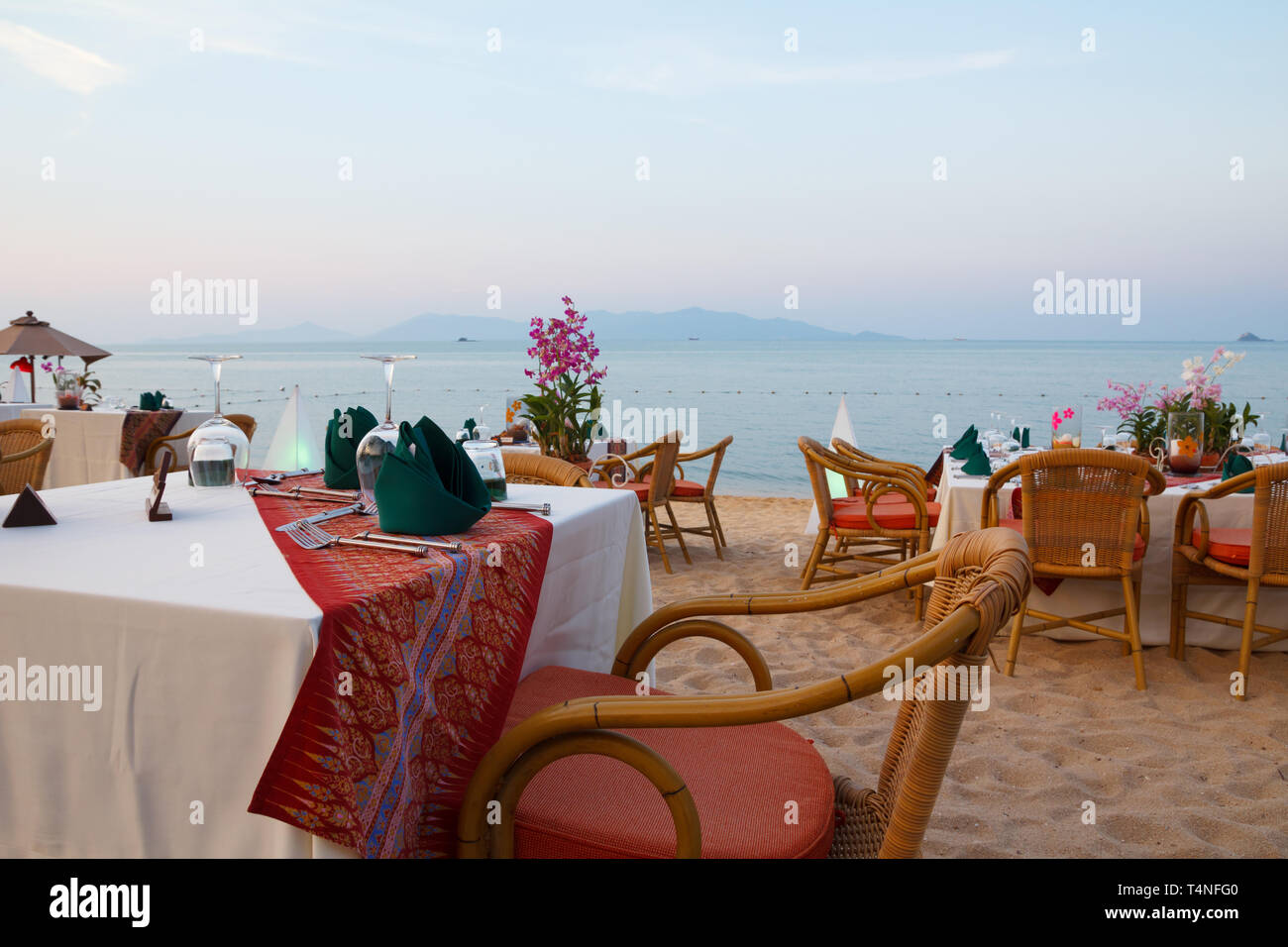 Outdoor restaurant tables, dinner setting at the beach on sunset Stock ...