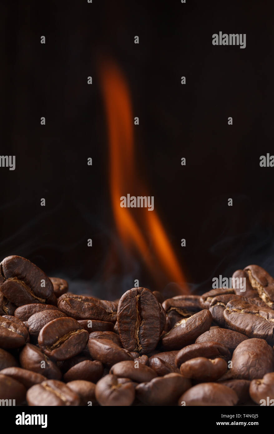 Coffee beans roasting with fire and smoke Stock Photo - Alamy