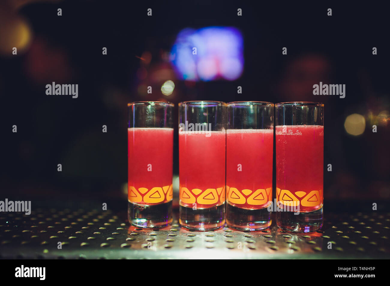 Barman make alcoholic red shots in nightclub Stock Photo - Alamy