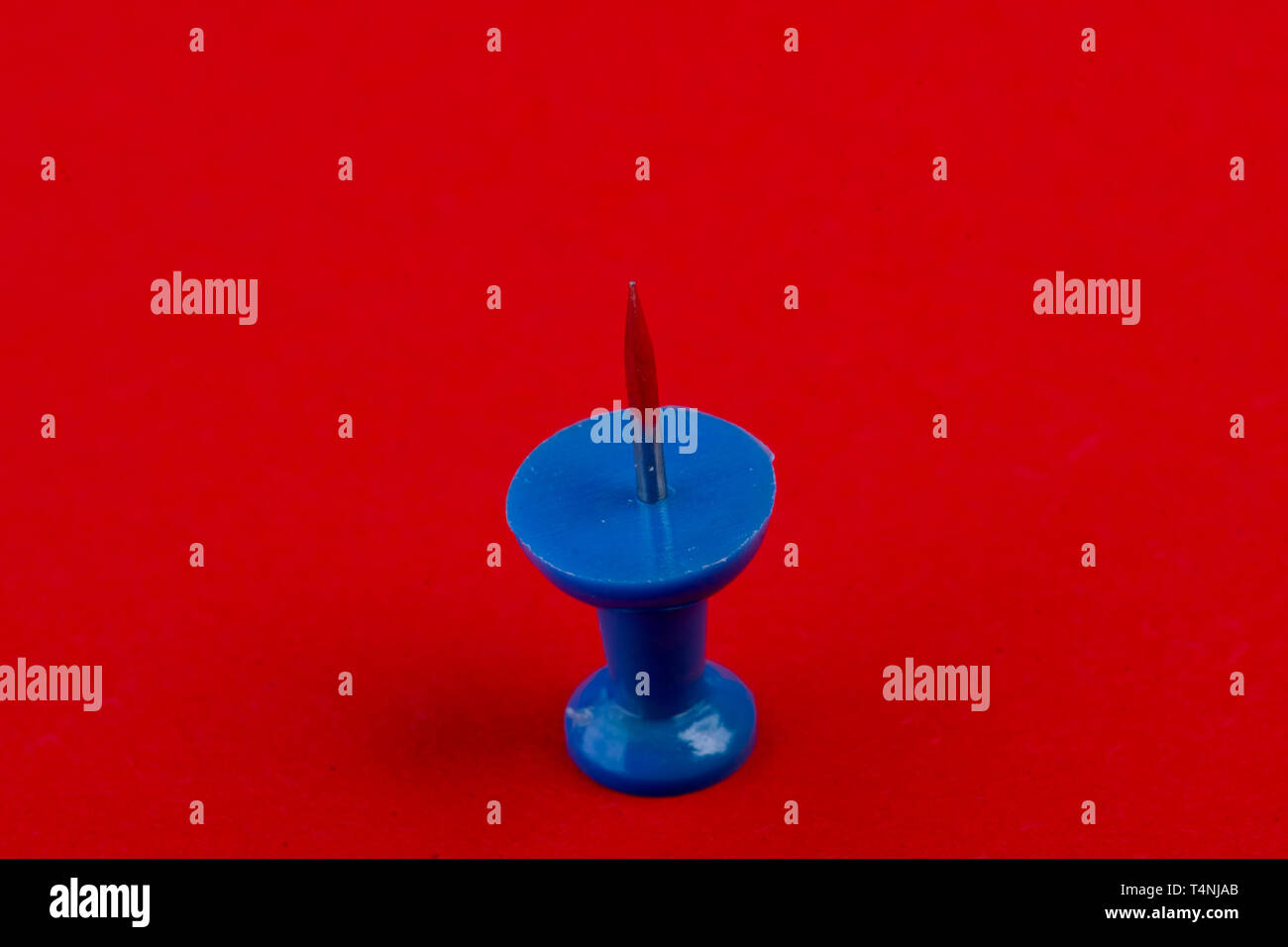 blue pin on red background Stock Photo - Alamy