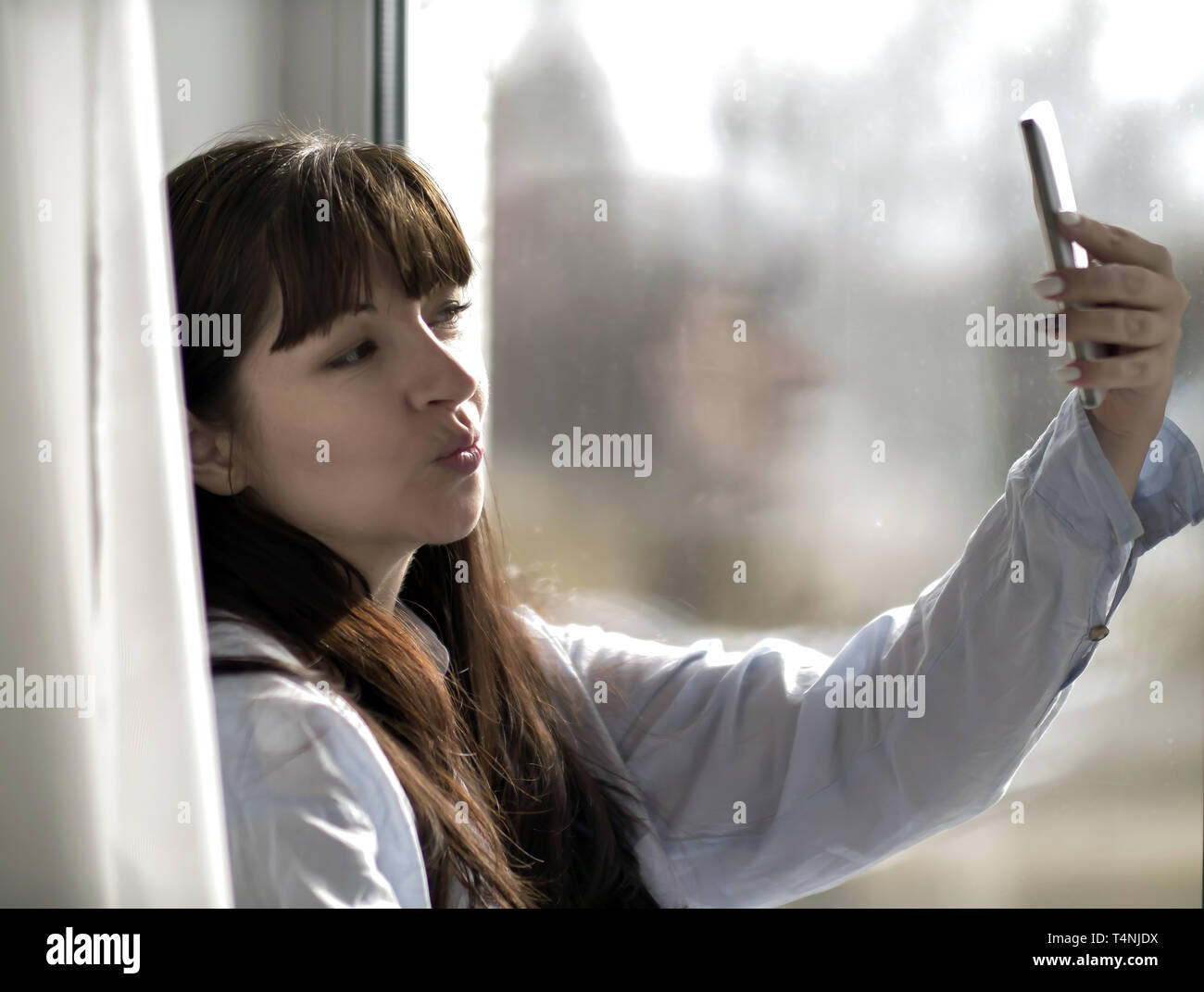 Young girl makes selfie while sitting by the window Stock Photo - Alamy