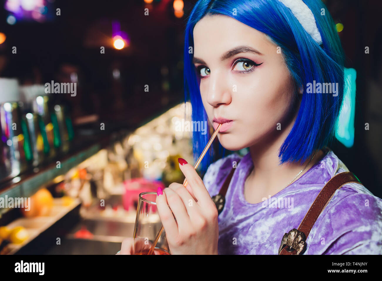 female bartender. girl with blue hair. cocktail making in night bar ...