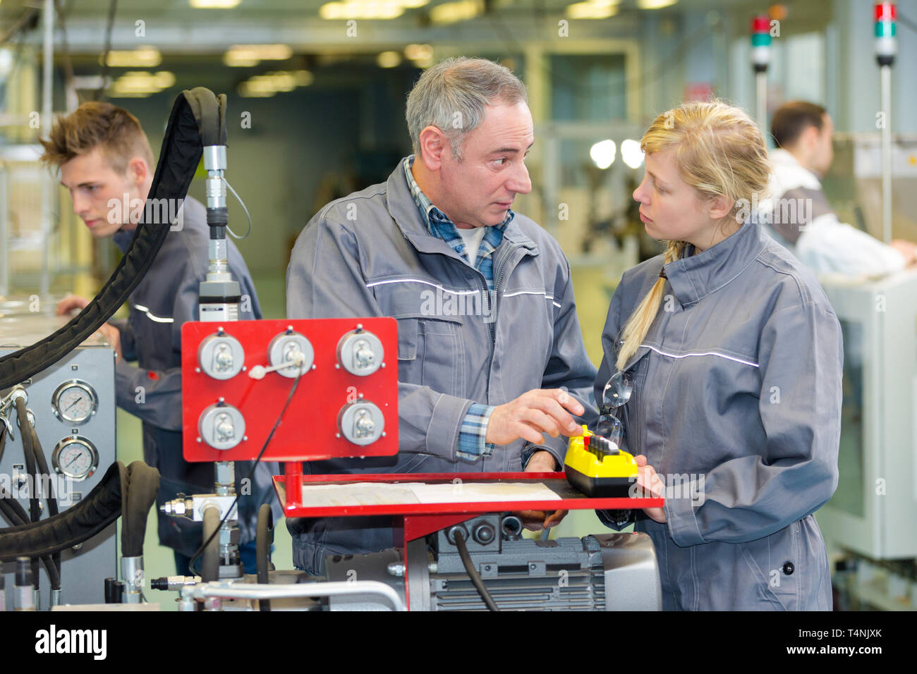 foreman training young female operative in factory Stock Photo - Alamy