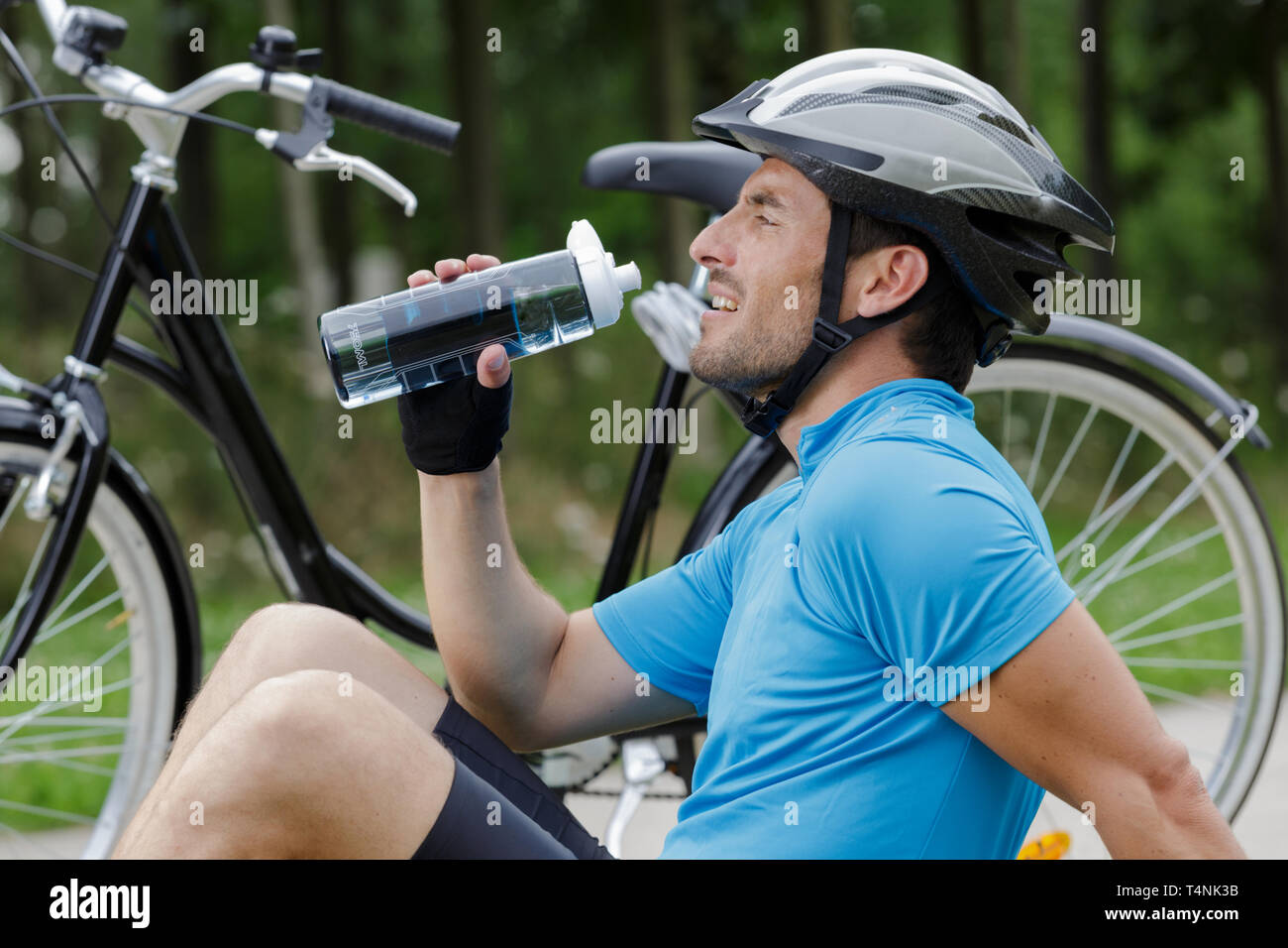 man drinking water while taking a rest for cycling Stock Photo - Alamy