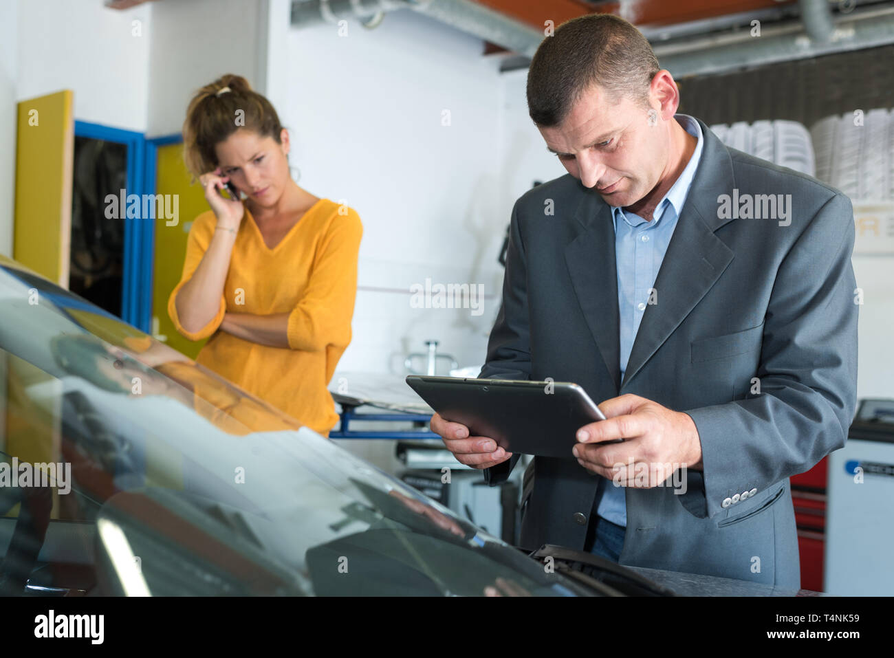 male insurance agent examining car after accident Stock Photo - Alamy