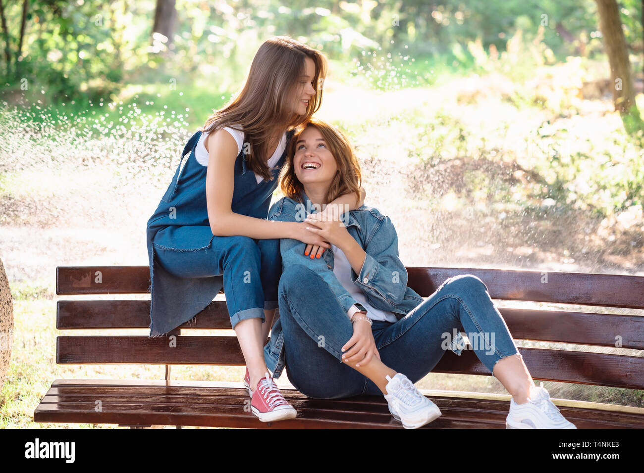 Two beautiful young woman resting on a bench Stock Photo - Alamy