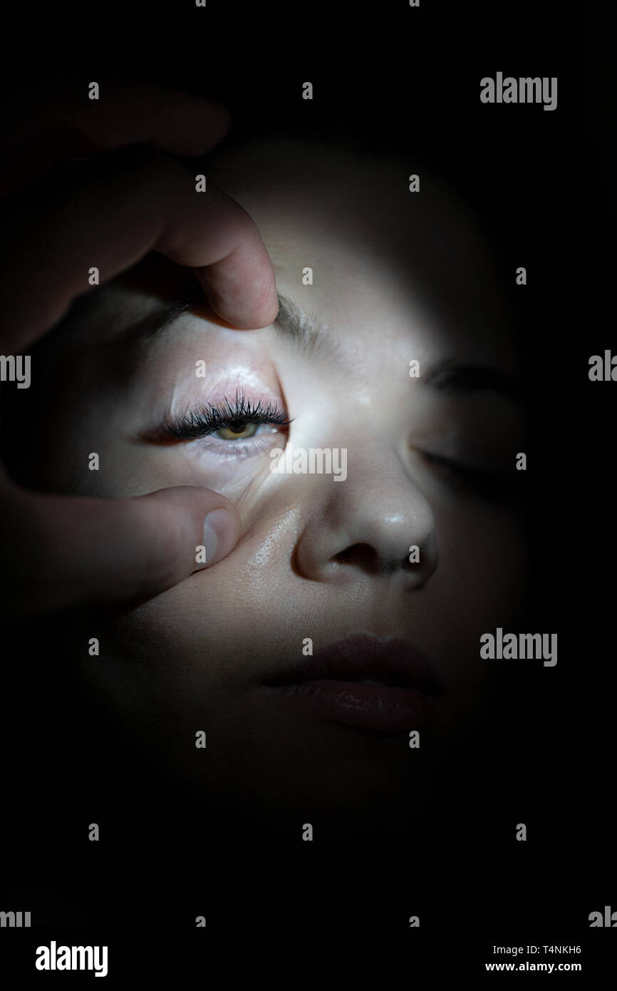 The doctor shines flashlights in the eye of the girl. A fainting ...