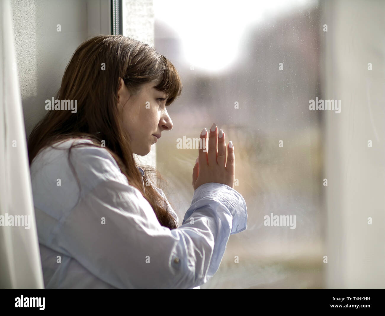 Sad girl looking out window white hi-res stock photography and images ...