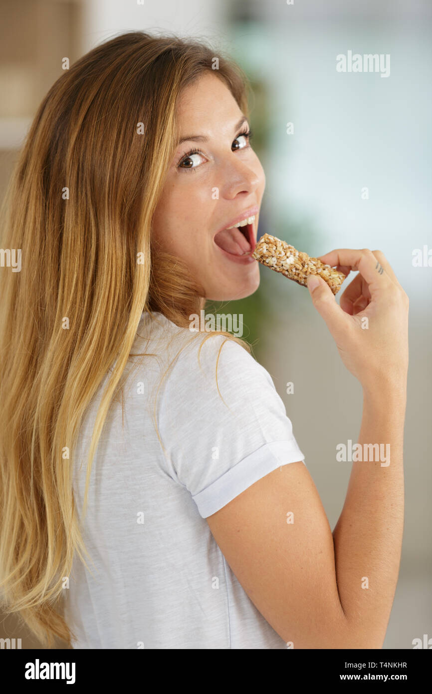 woman eating a muesli bar Stock Photo - Alamy