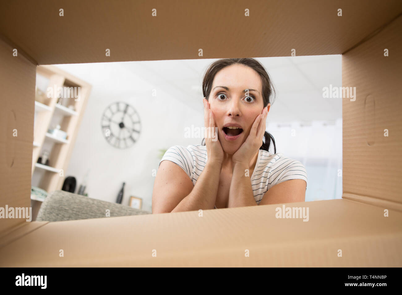 happy surprised woman opening a box looking into it Stock Photo - Alamy