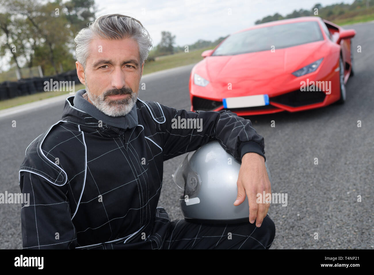 race car driver posing with his helmet Stock Photo - Alamy