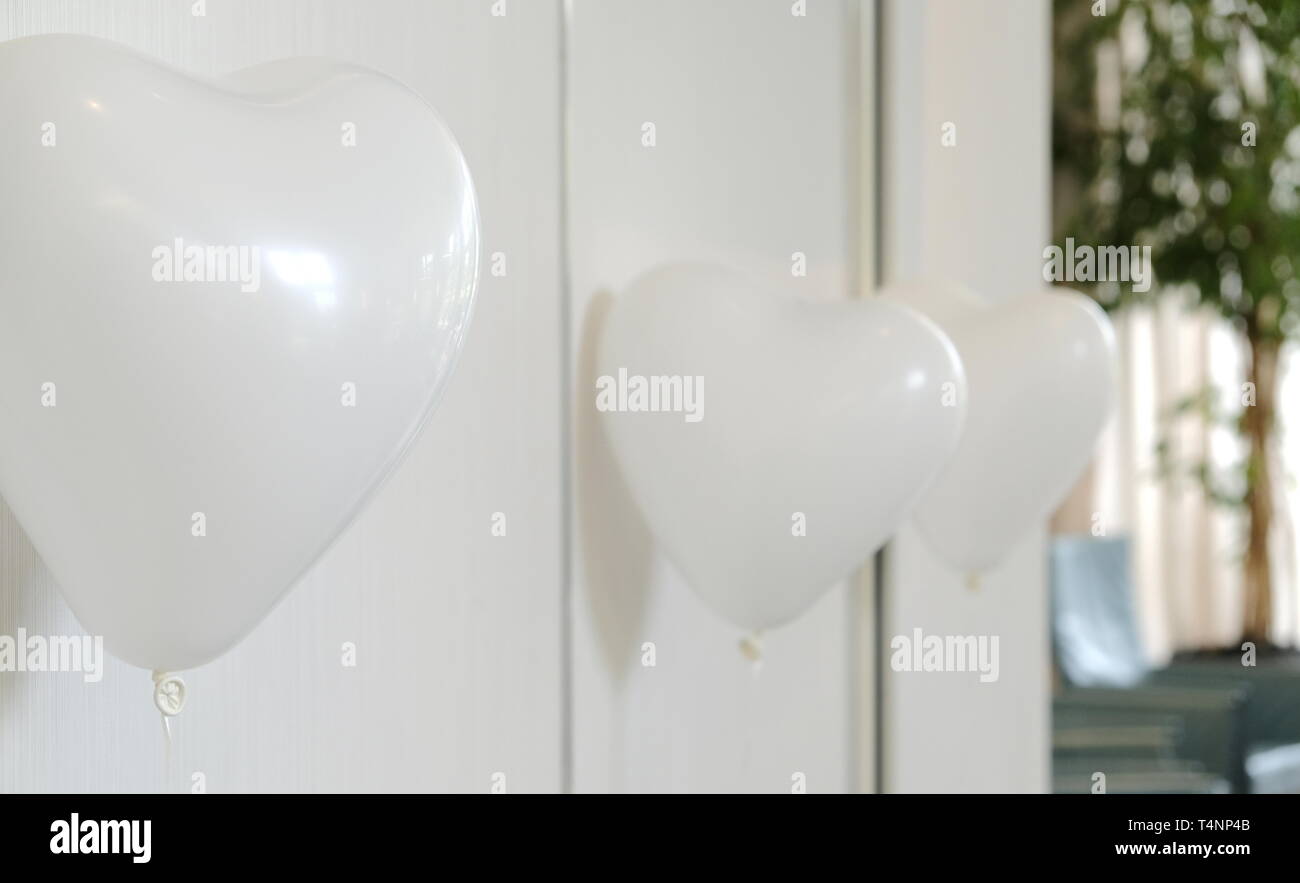 white heart shaped balloons on a wall at a wedding Stock Photo - Alamy