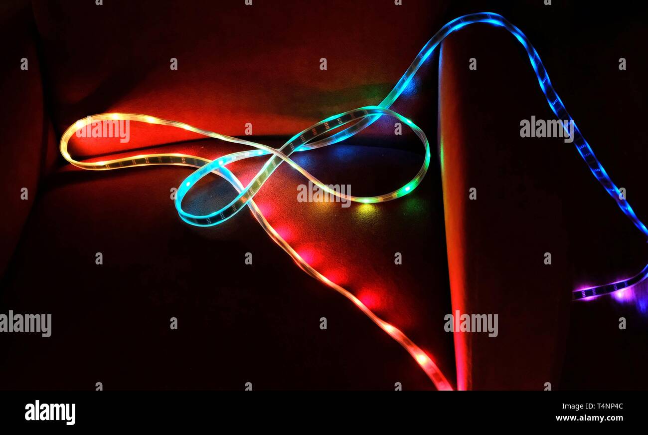colorful led light strip on a red chair in the dark Stock Photo - Alamy