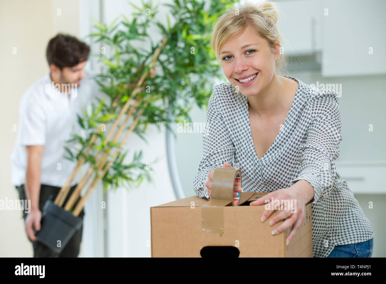 woman closing boxes to move to her new house Stock Photo - Alamy