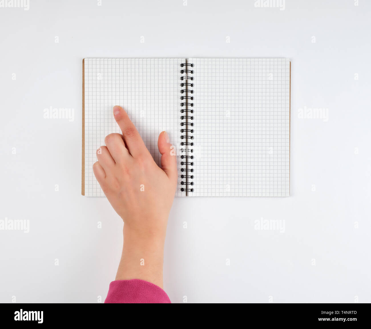 empty open notebook in a cell and female hand, white background, top ...