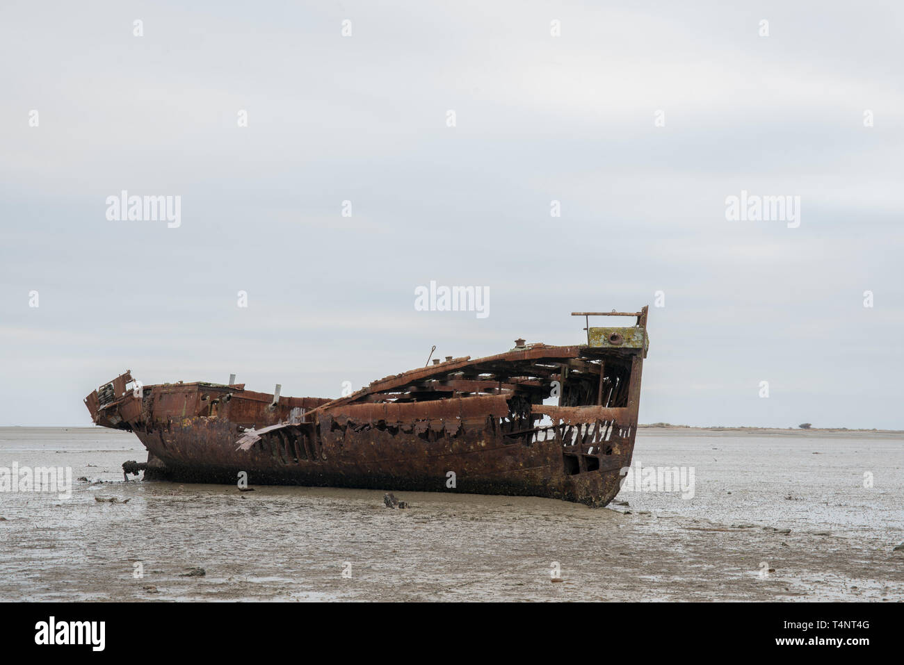 The abandoned rusty ruins of a ship wreck on Port Motueka beach Stock ...
