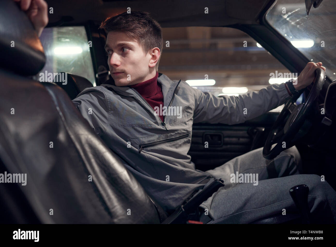 Photo from side of man driver looking back while sitting in car Stock ...