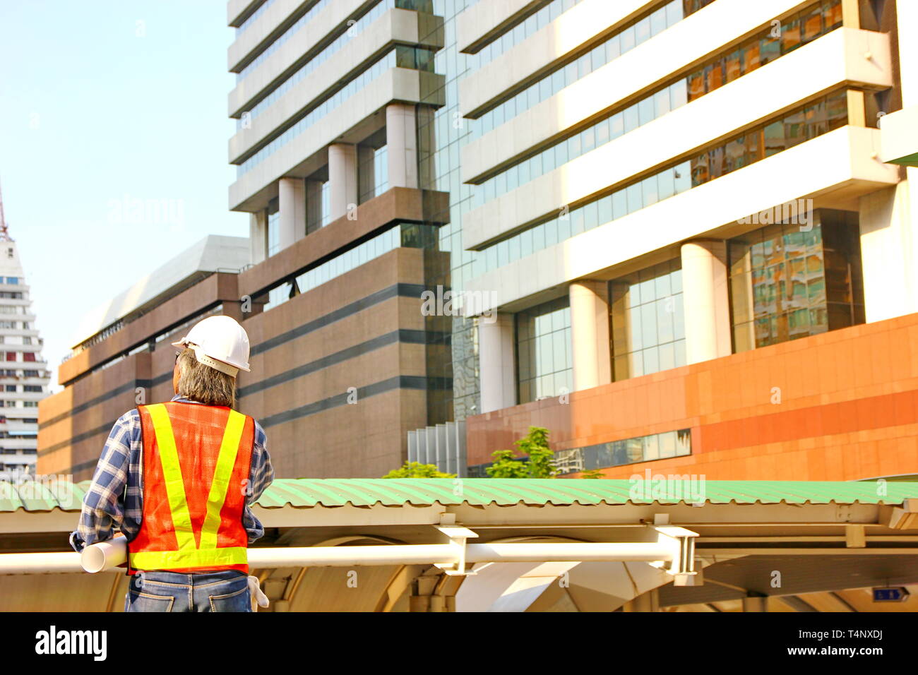 the worker in safety form standing on sky walk and looking his ...