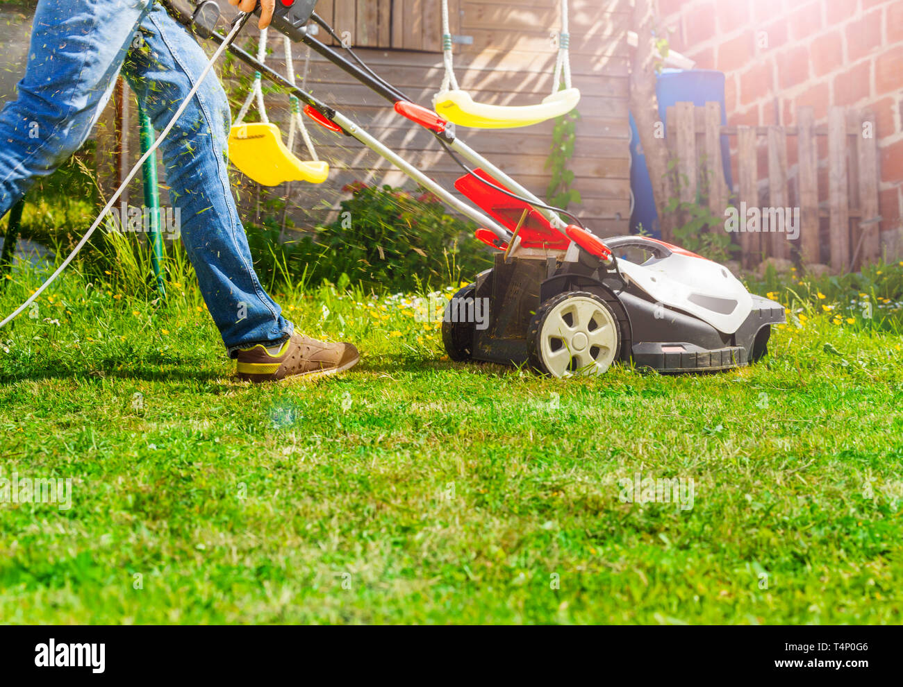 Lawn mower man using walk behind lawnmower Stock Photo - Alamy