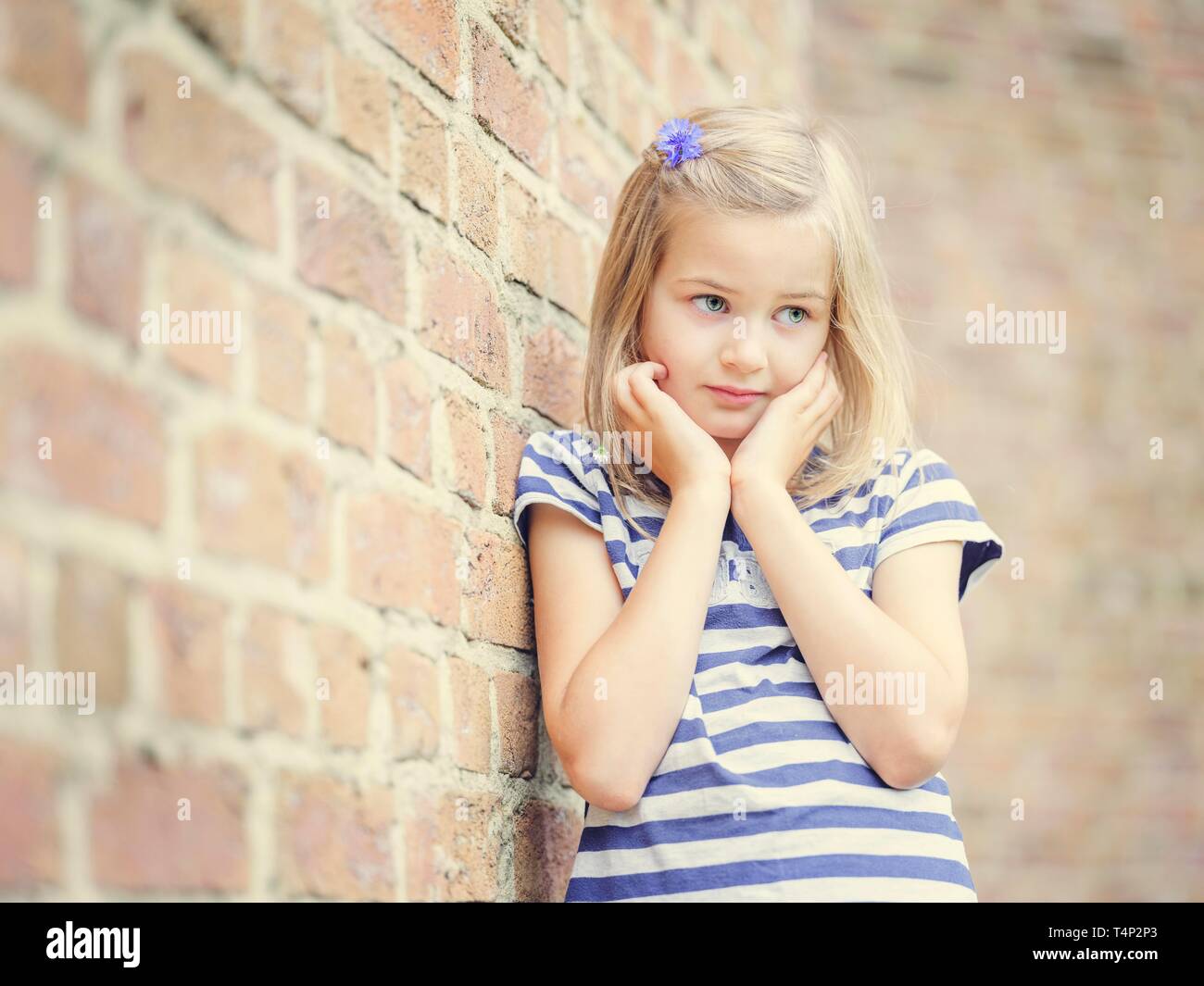 Girl, 10 years, leans against a wall, shy look, Portrait, Germany Stock ...