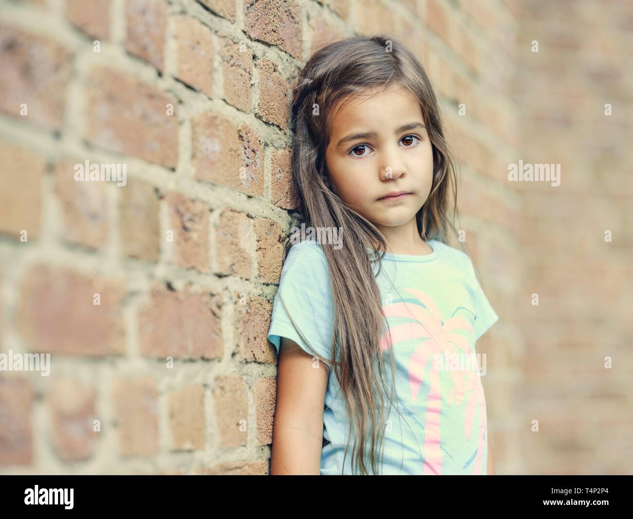 Child leaning against brick wall hi-res stock photography and images ...