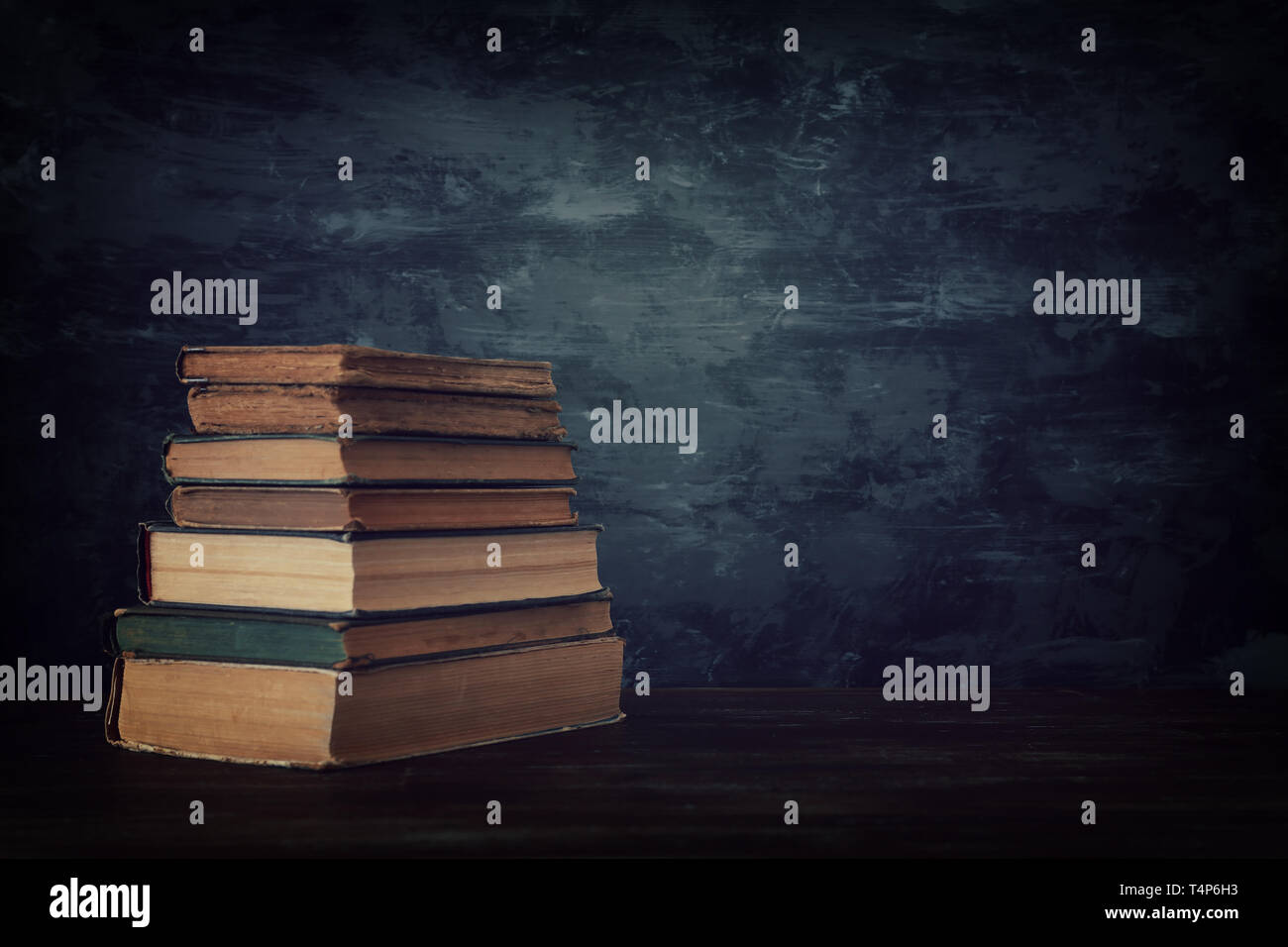 stack of antique books on old wooden table. fantasy medieval period and ...