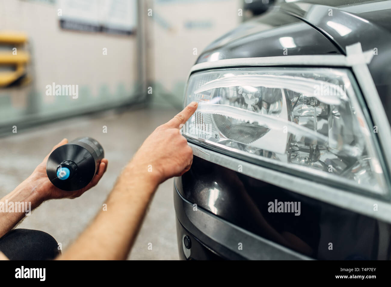 Auto detailing of car headlights on carwash service. Man smears ...