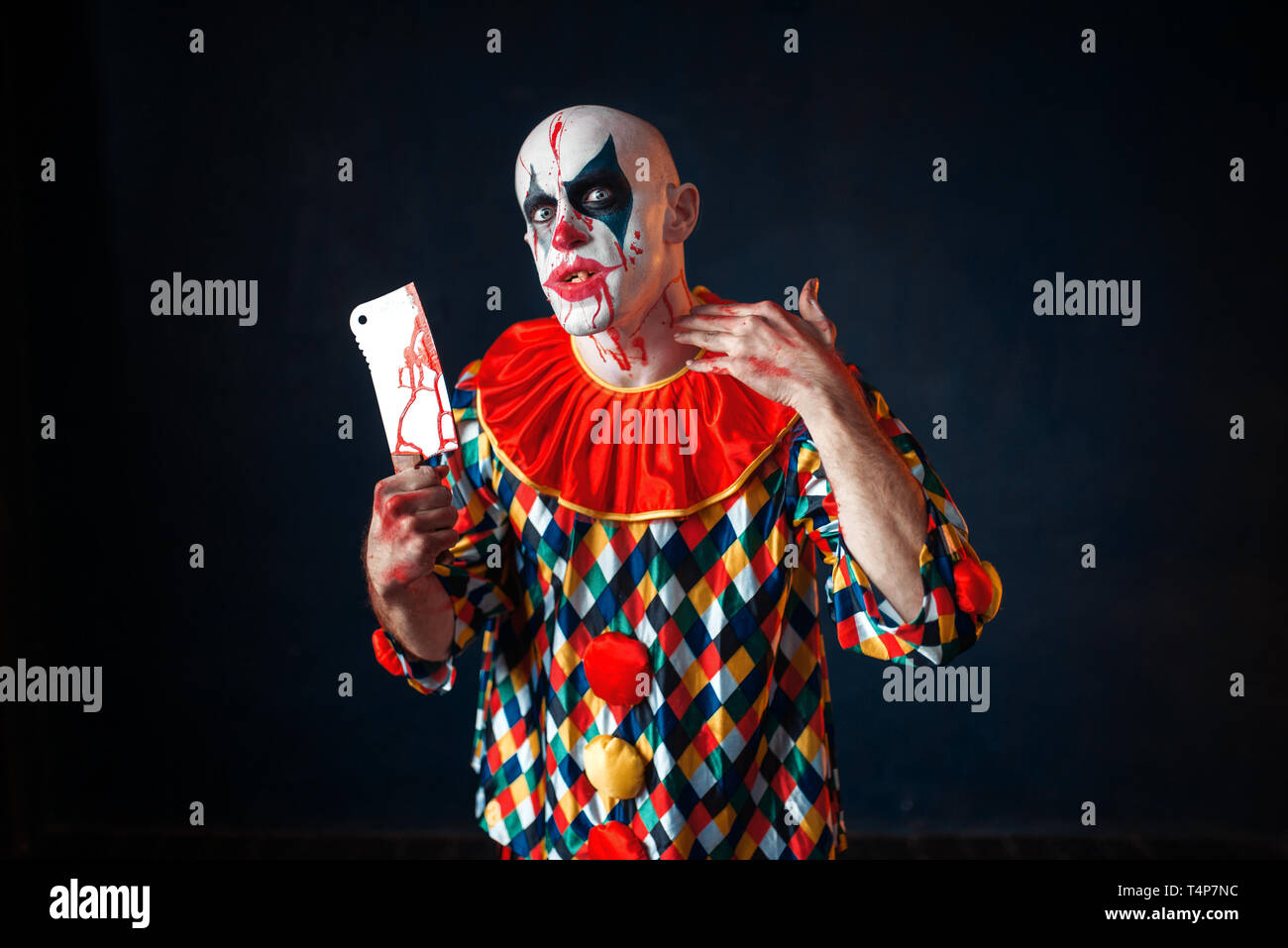Mad bloody clown with meat cleaver, circus horror. Man with makeup in ...