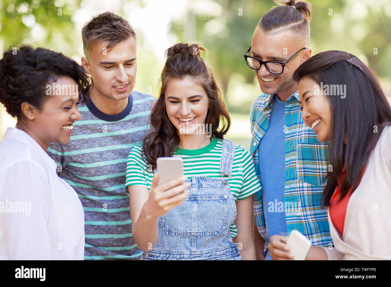 friendship, technology and international concept - group of happy ...