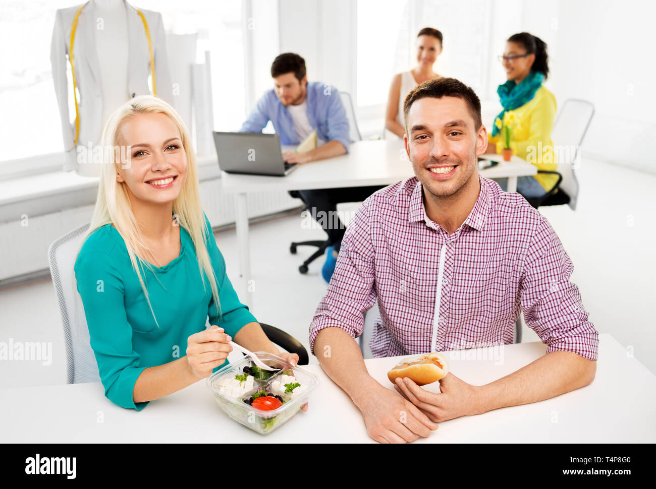 corporate, food and people concept - happy colleagues having lunch and ...