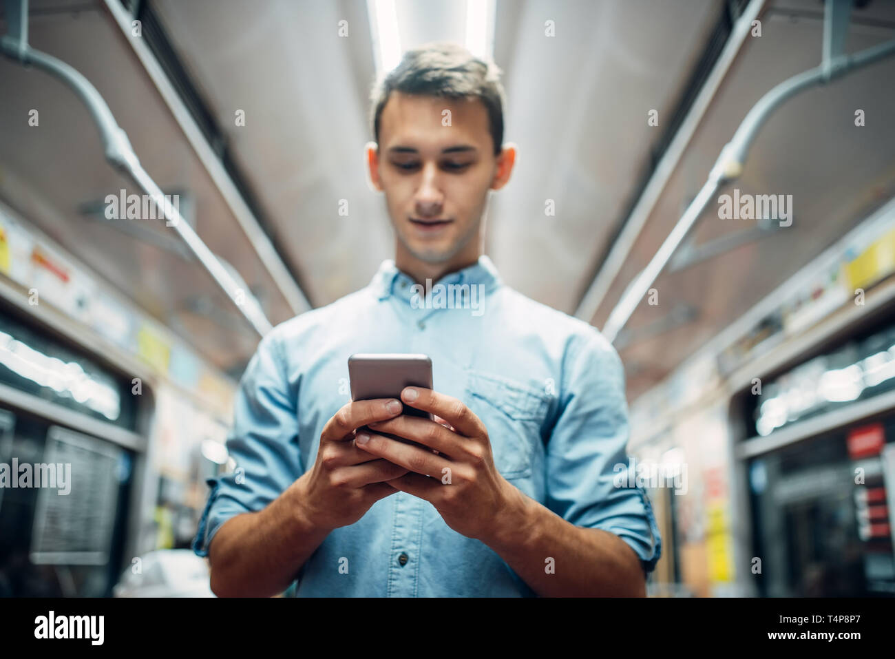 Young man using phone in subway car, addiction problem, social addicted ...