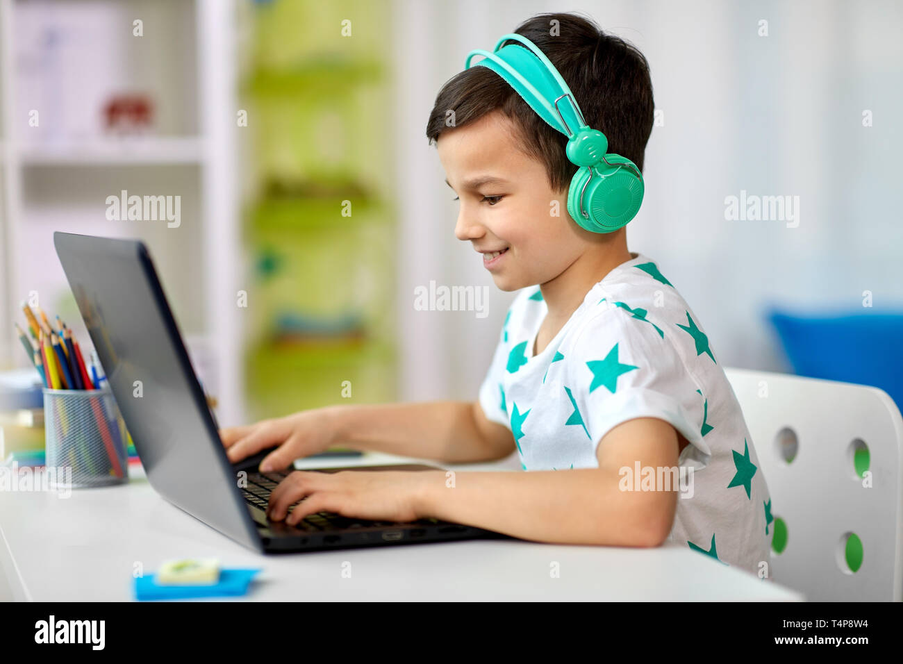 technology, gaming and people concept - boy in headphones playing video ...