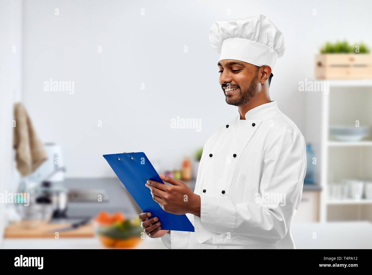 cooking, profession and people concept - happy male indian chef in ...