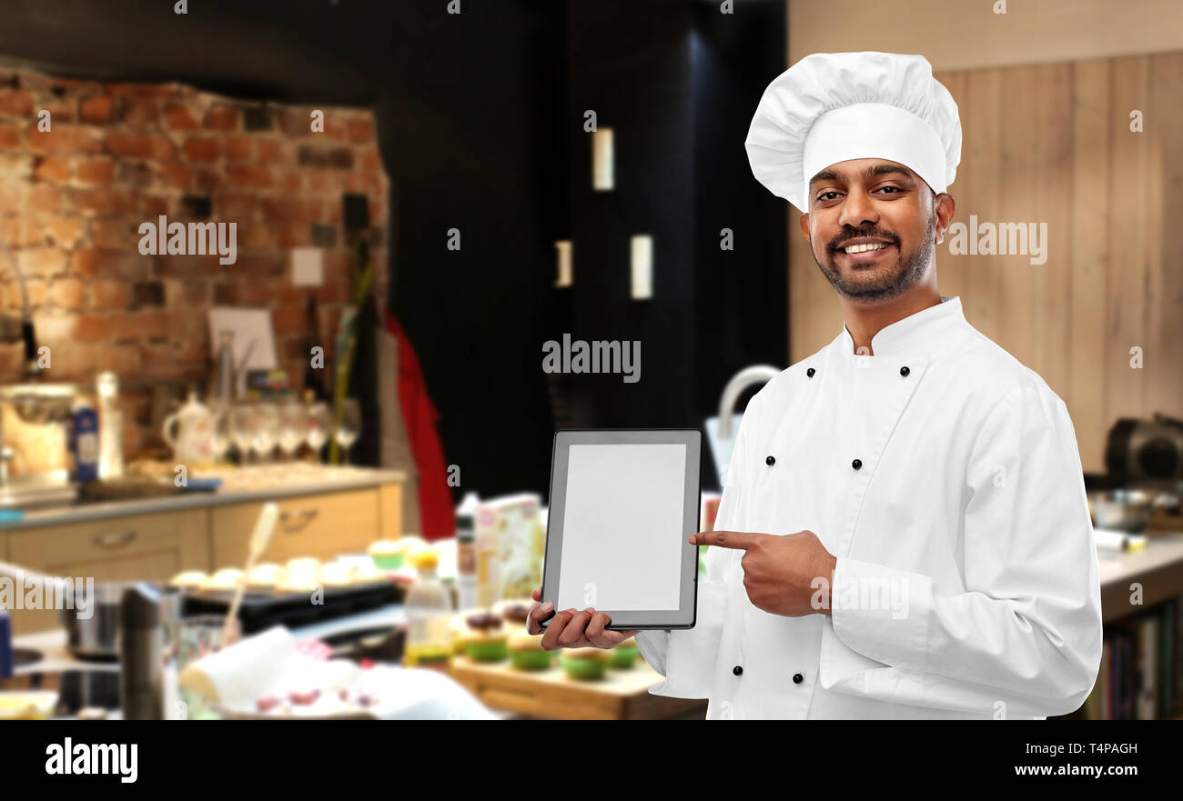 cooking, technology and people concept - happy male indian chef in ...