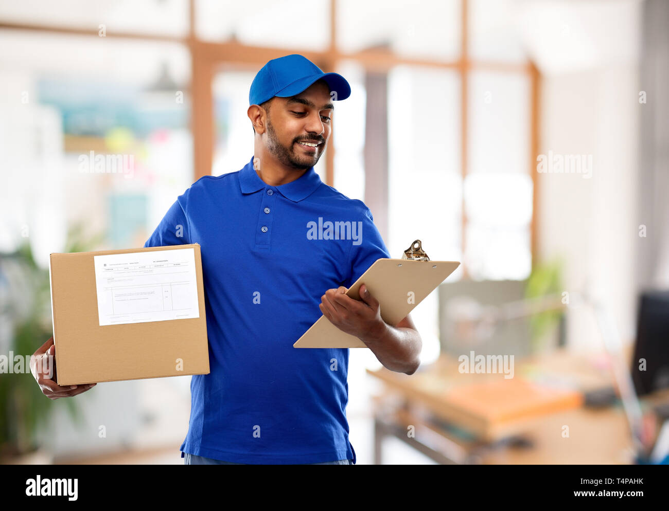 mail service and shipment concept - happy indian delivery man with ...