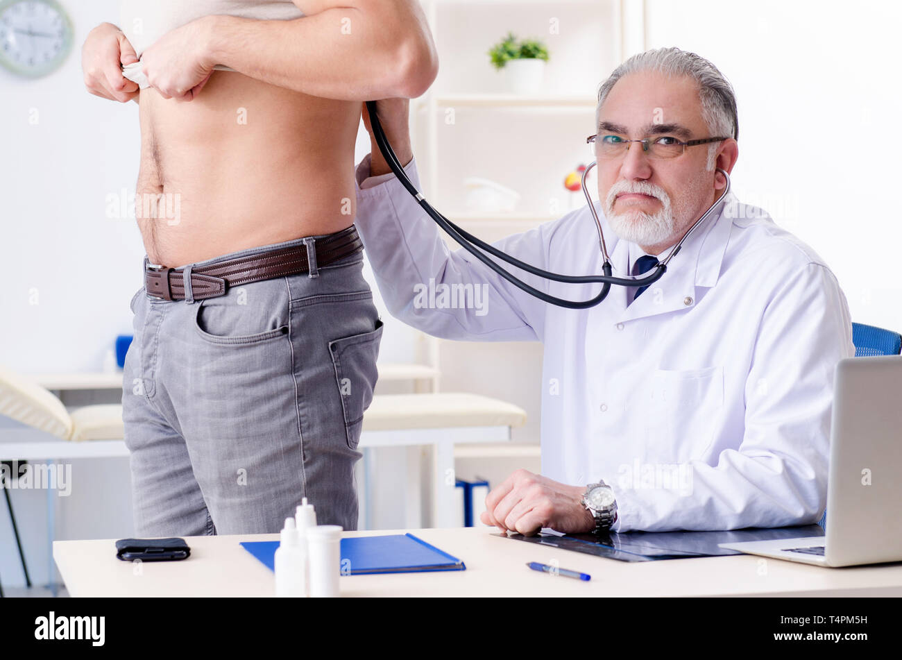 Young male patient visiting old doctor Stock Photo - Alamy