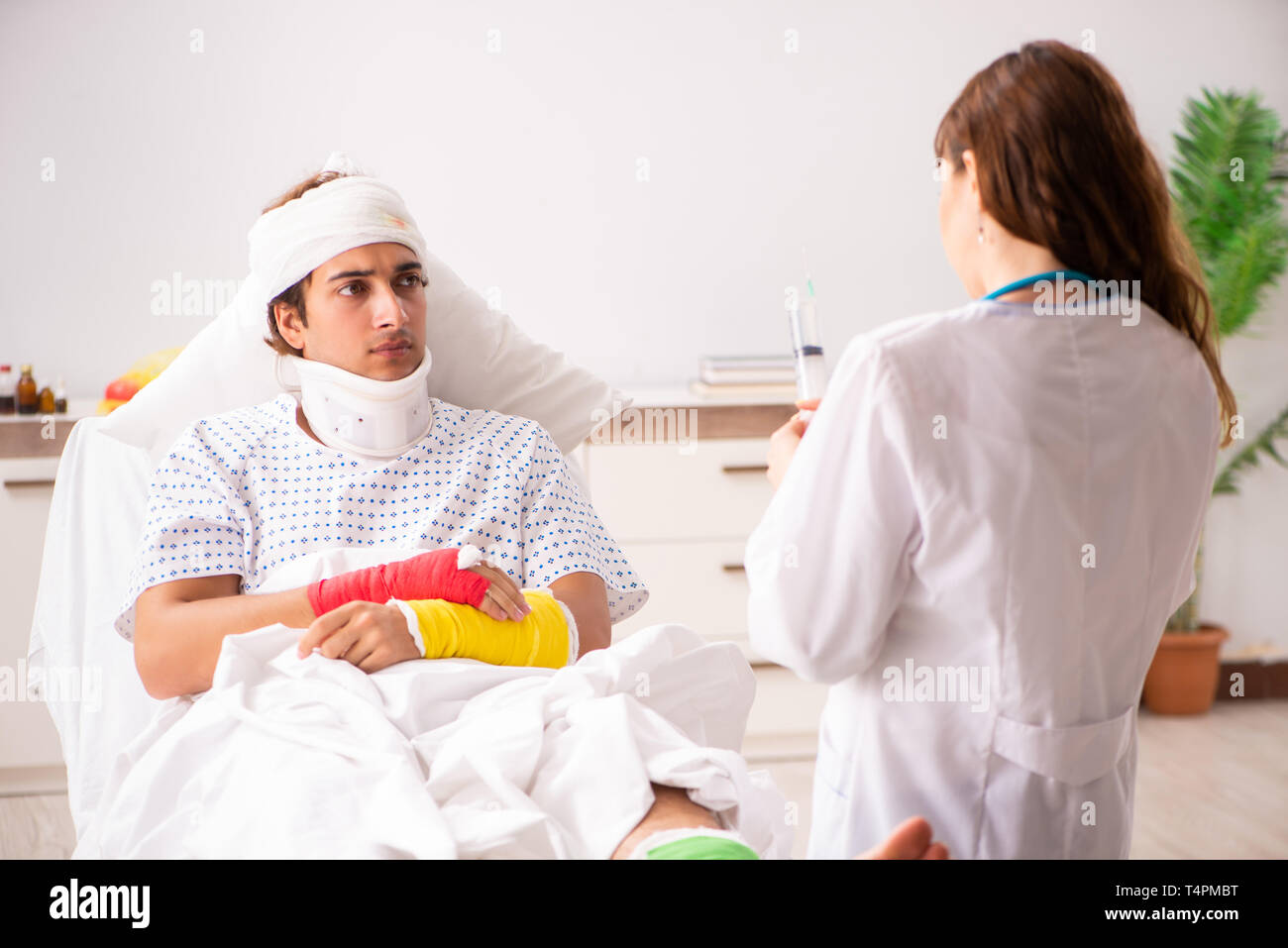 Young doctor examining injured patient Stock Photo - Alamy